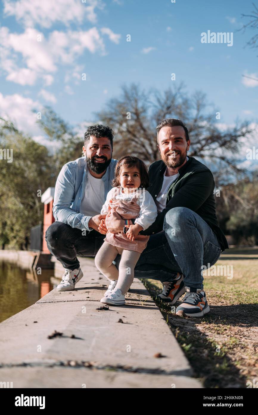Portrait of a modern family in the park with two male parents and a ...
