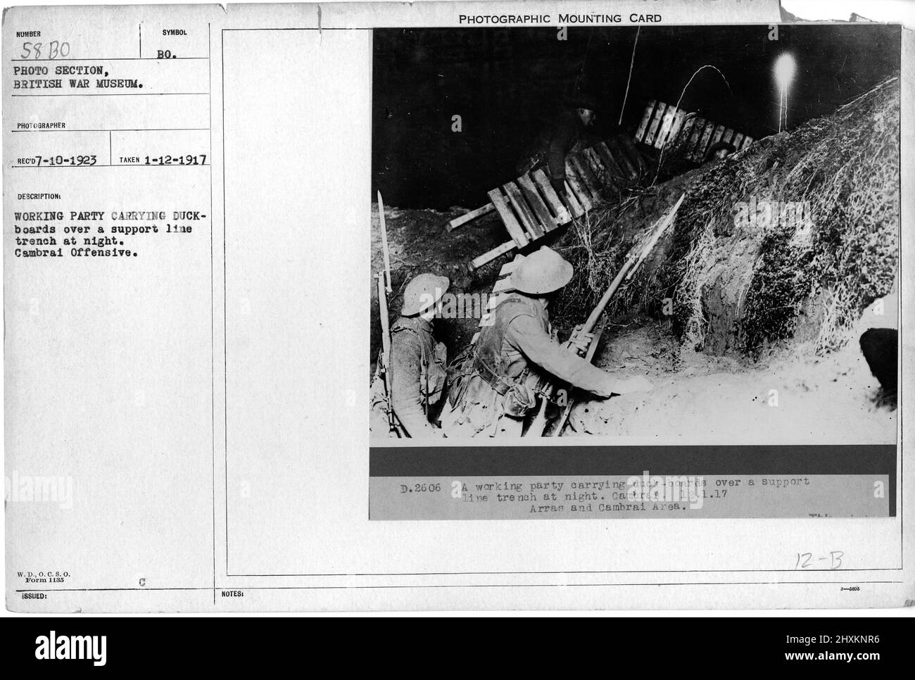 Working party carrying duck-boards over a support line trench at night ...