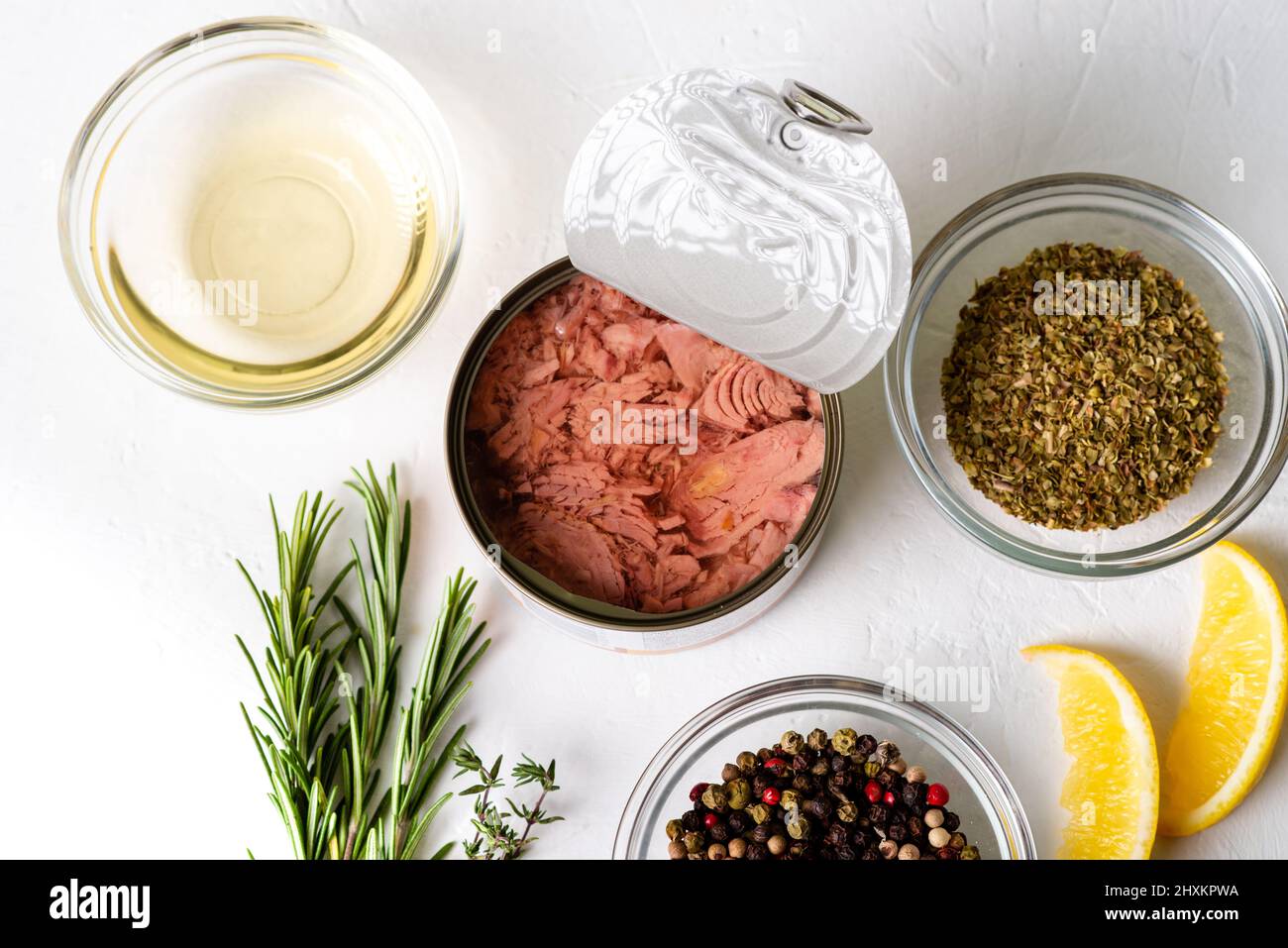 Open canned tuna. White background. Radom spices, herbs. Preparing ...