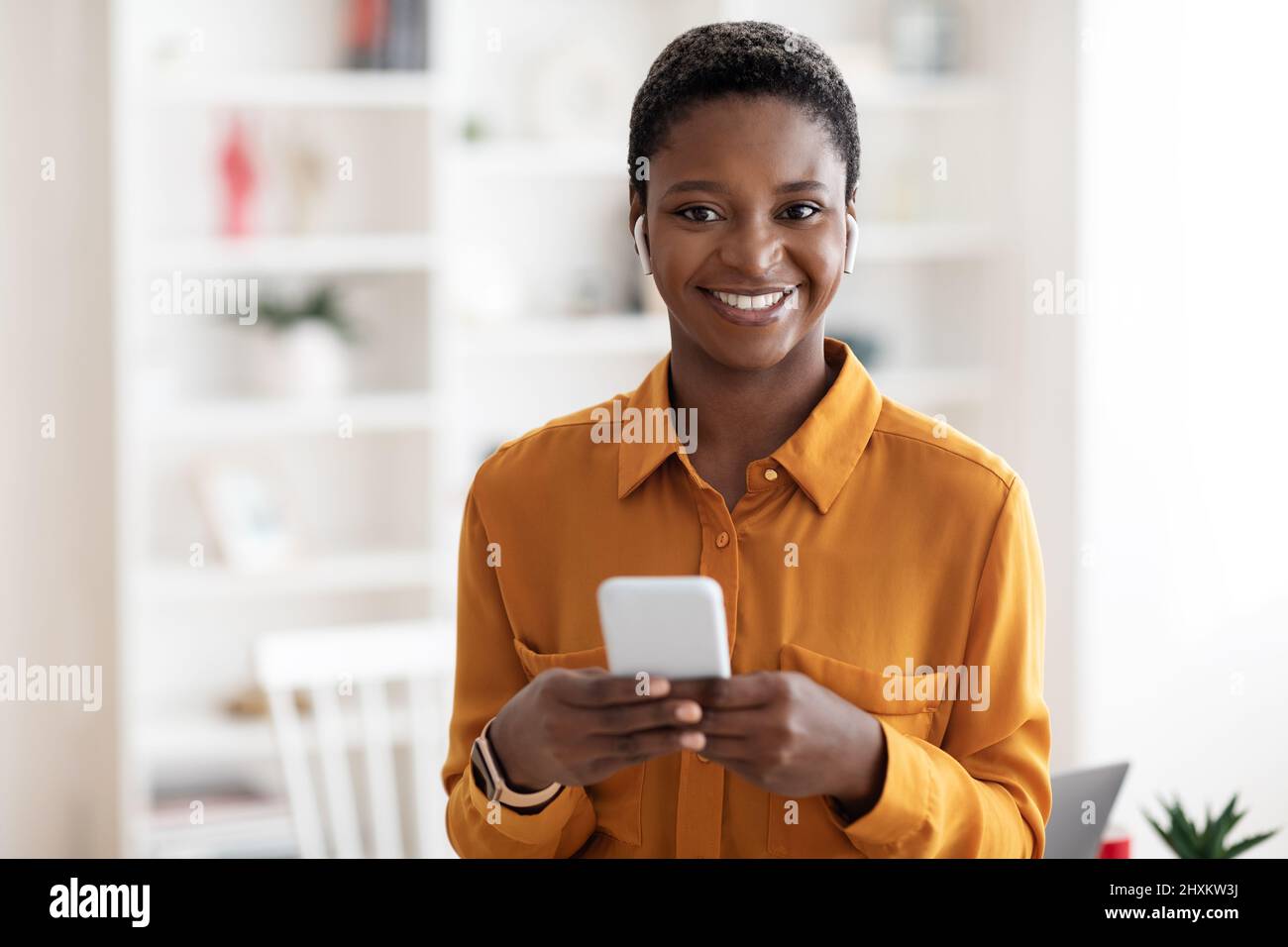 Stylish black lady with earbuds and smartphone Stock Photo - Alamy