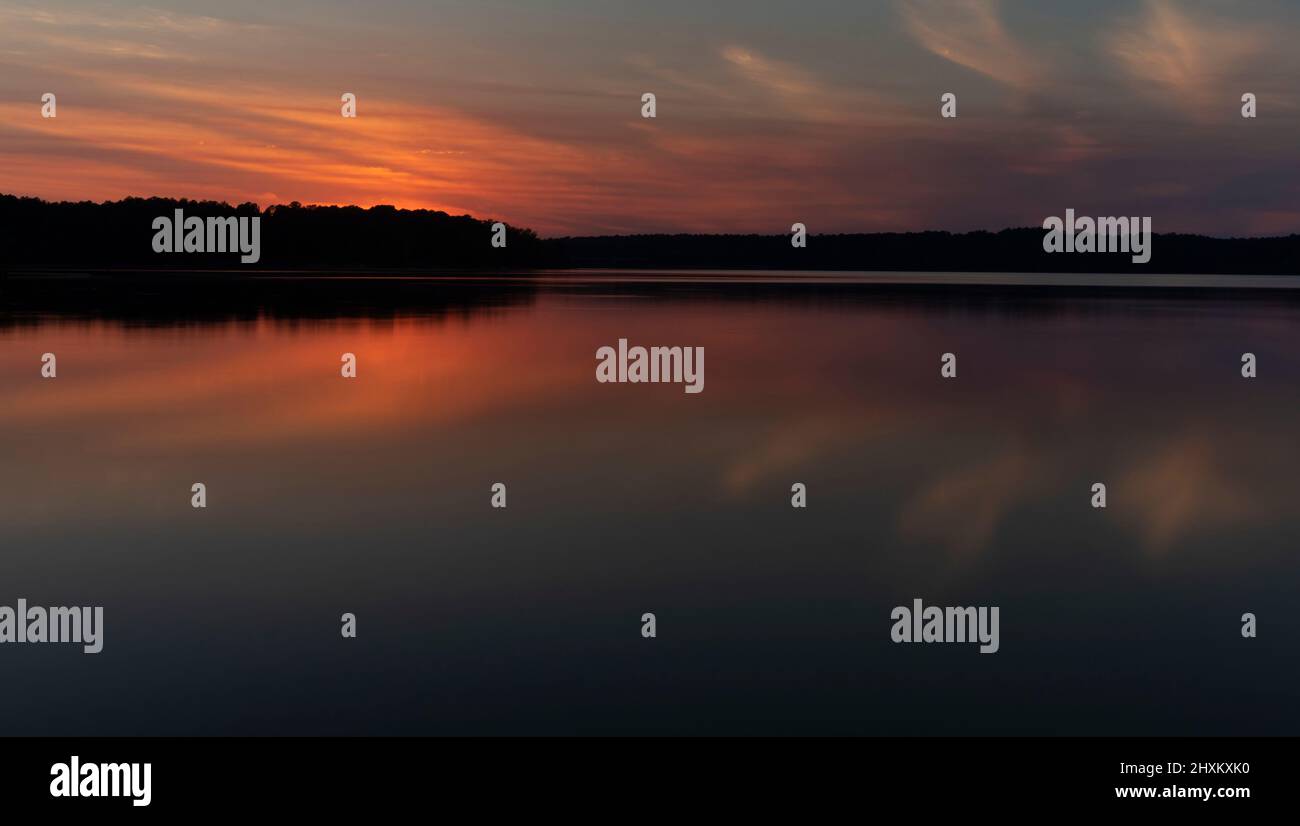 Sun just under the treeline at Jordan Lake in North Carolina Stock ...