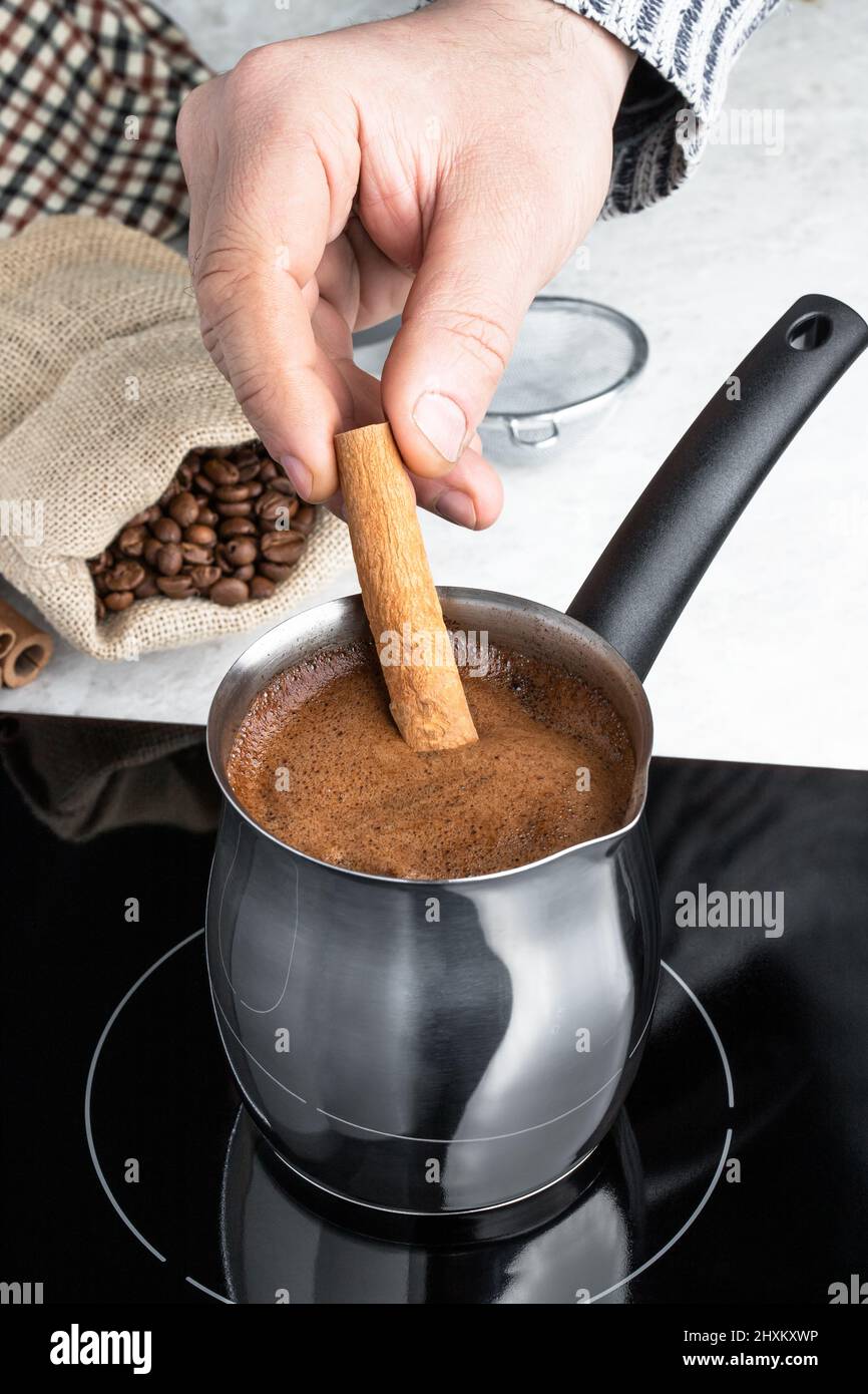 Induction hob coffee making with cinnamon stick added Stock Photo - Alamy