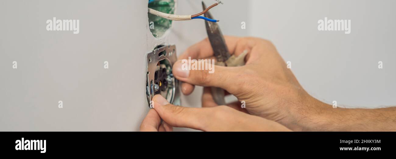Master electrician installs a socket in the house BANNER, LONG FORMAT ...