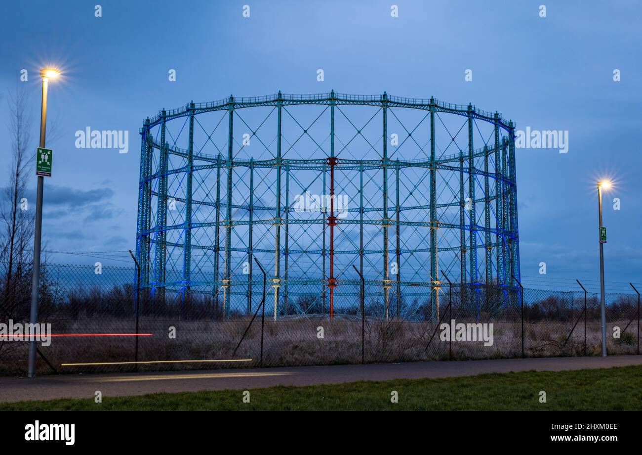 Light trails past Granton gas holder lit up in solidarity at dusk in ...