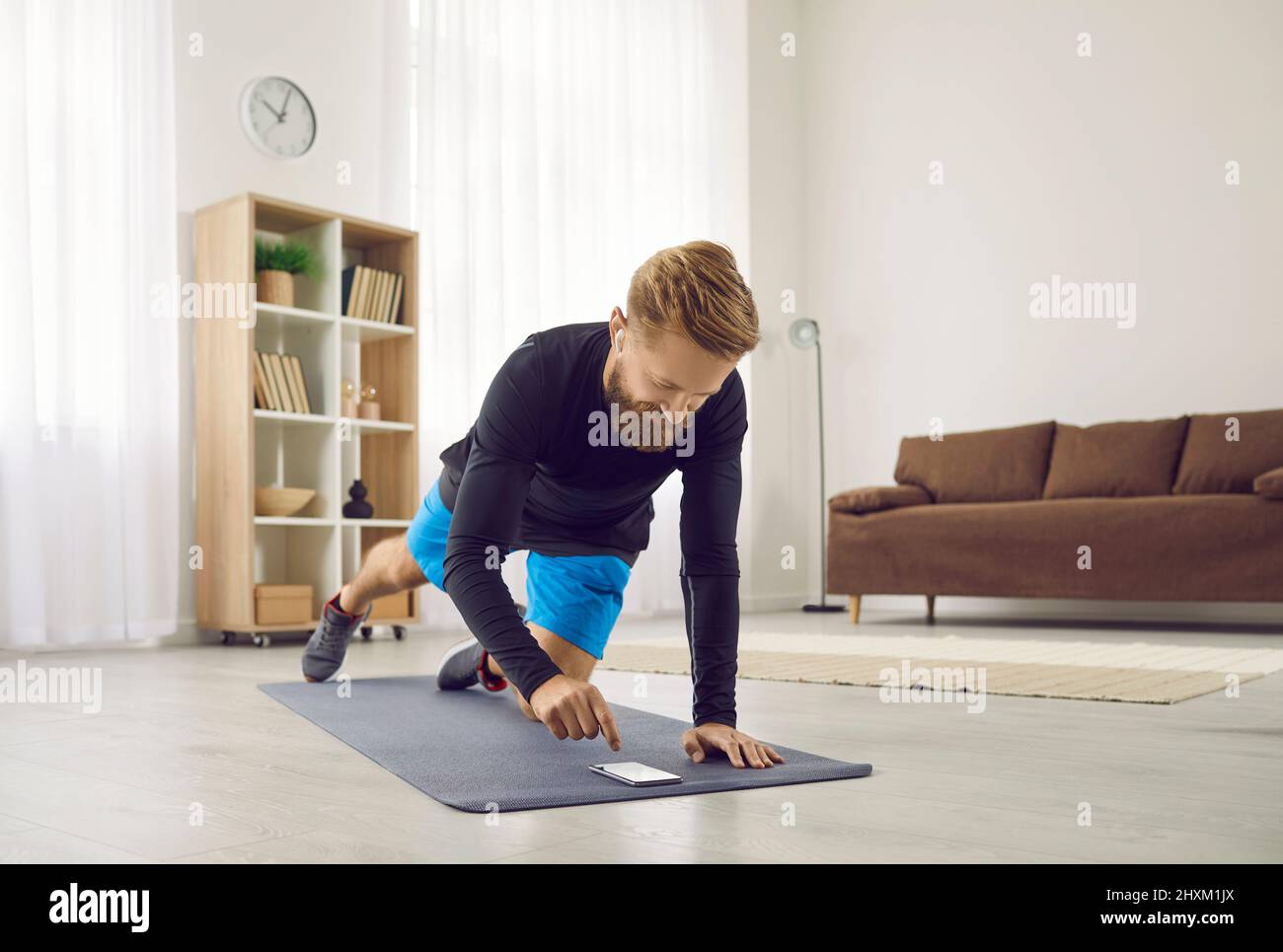 Active man train at home with smartphone app Stock Photo - Alamy