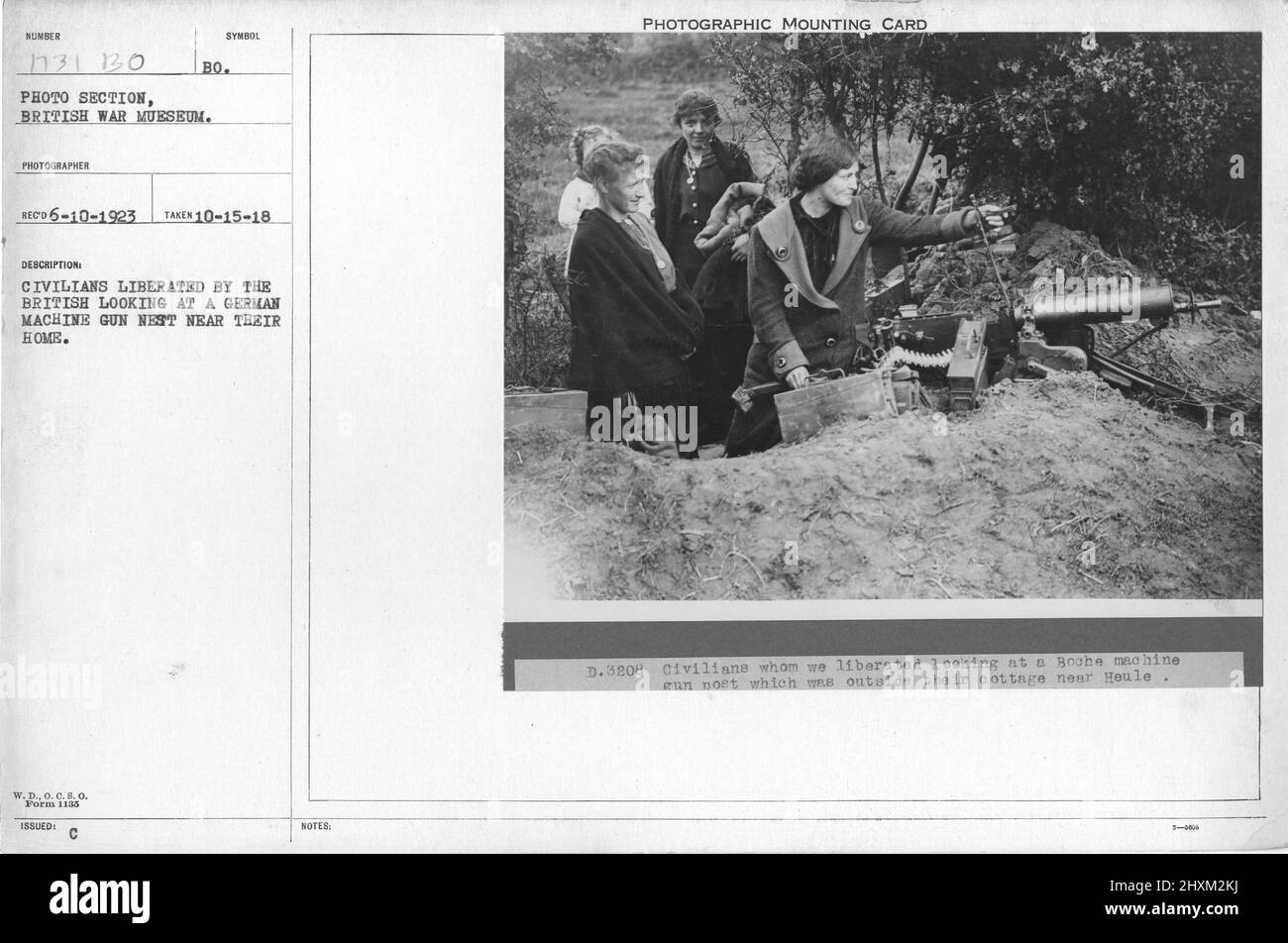 Civilians liberated by the British looking at a German machine gun nest ...