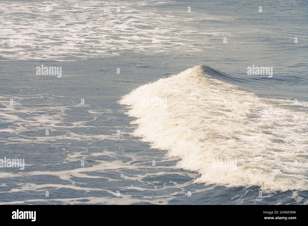 Stunning sea view of a sunlit wave approaching the coast. Concept of ...