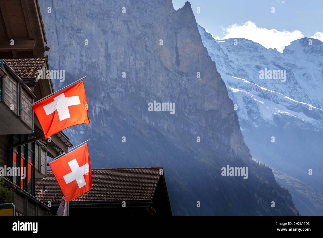 Alpine village houses with flags, snow Swiss Alps, Switzerland Stock ...
