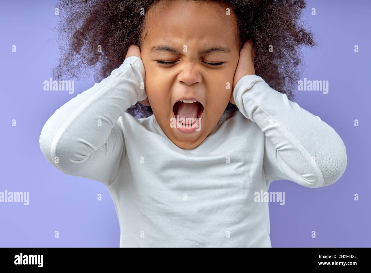 Irritated black girl isolated on purple studio background close plug ...