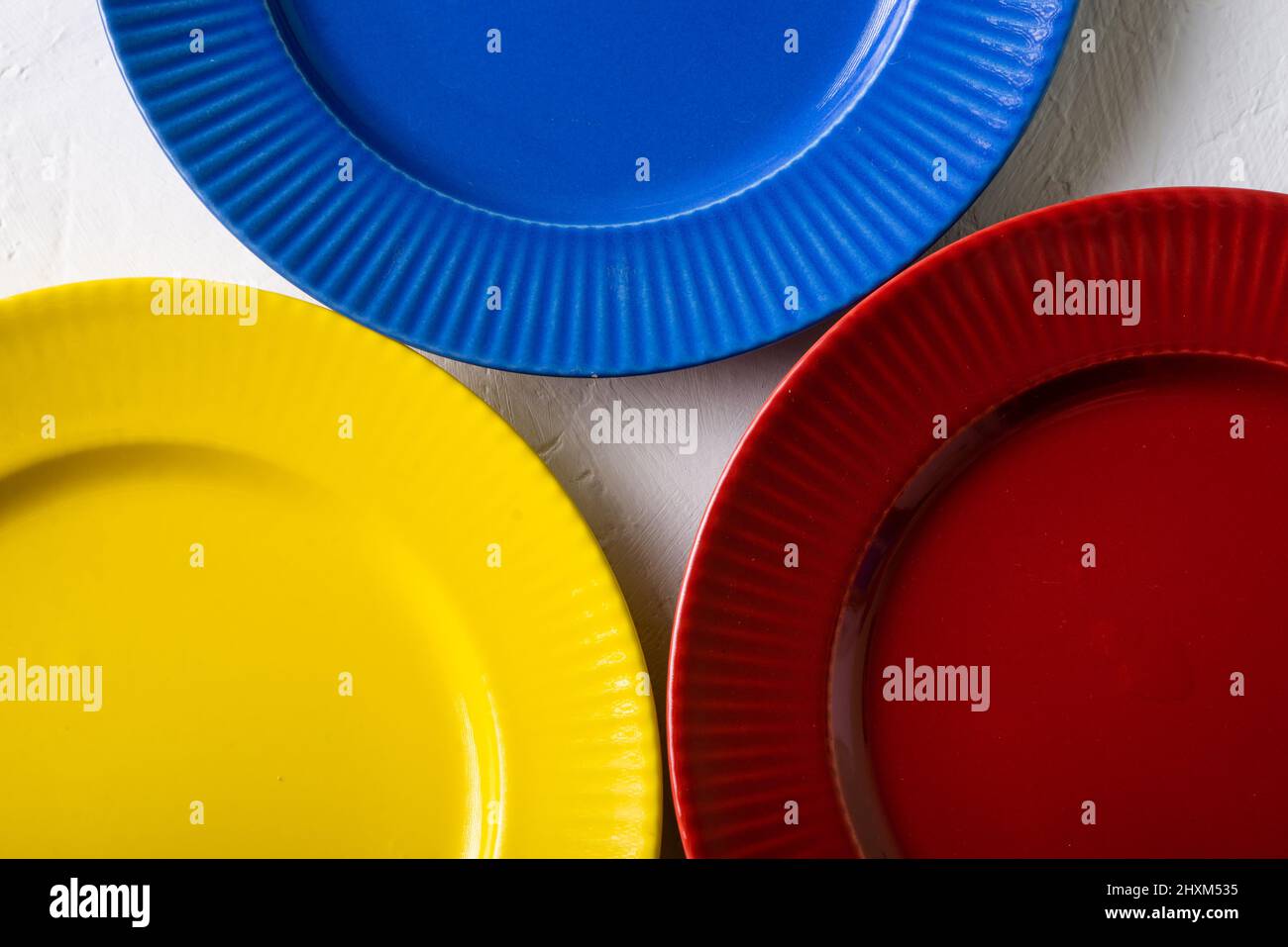 Different colors of empty plates. White background. Red, blue and ...