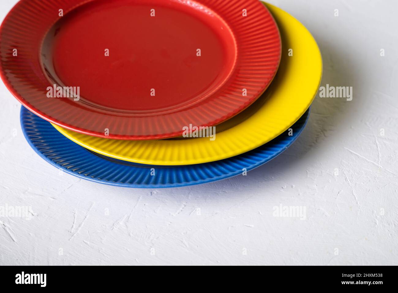 Different colors of empty plates. White background. Red, blue and ...