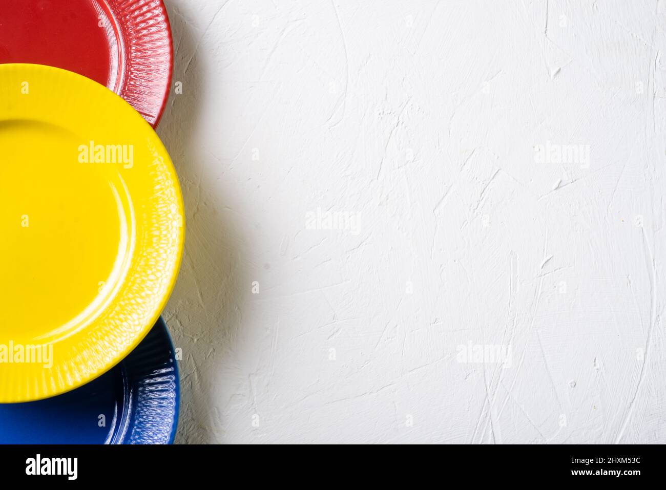 Different colors of empty plates. White background. Red, blue and ...