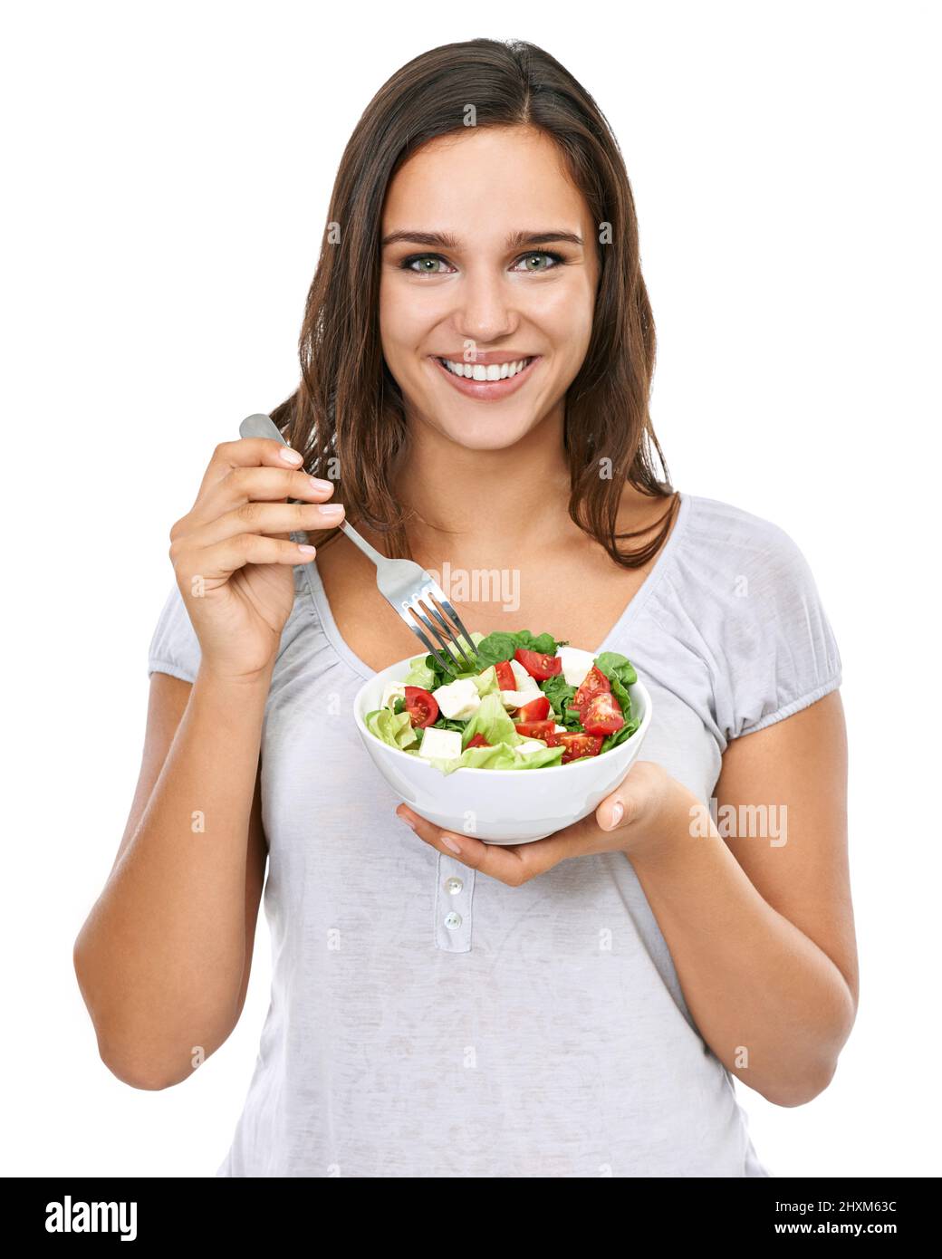 Enjoying a healthy snack. A young woman enjoying a fresh salad isolated on white Stock Photo - Alamy
