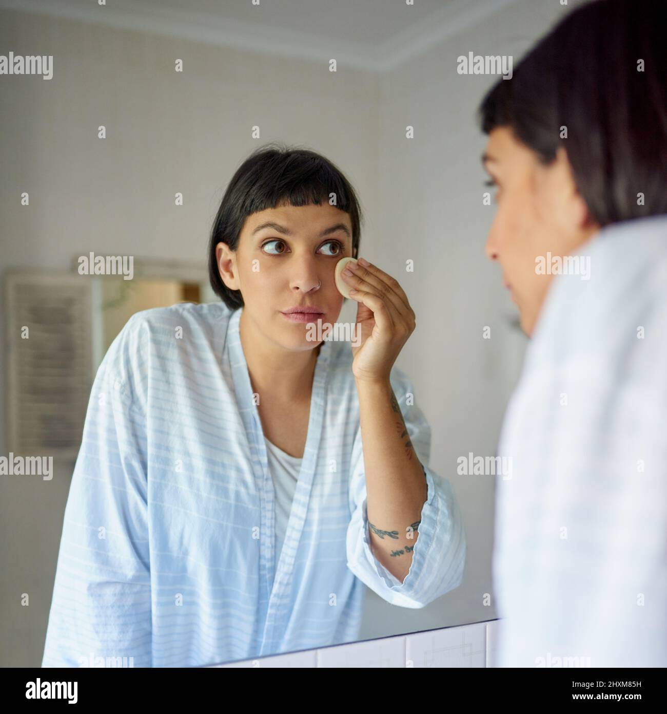 Shes perfected her morning routine. Shot of a young woman in a bathrobe ...