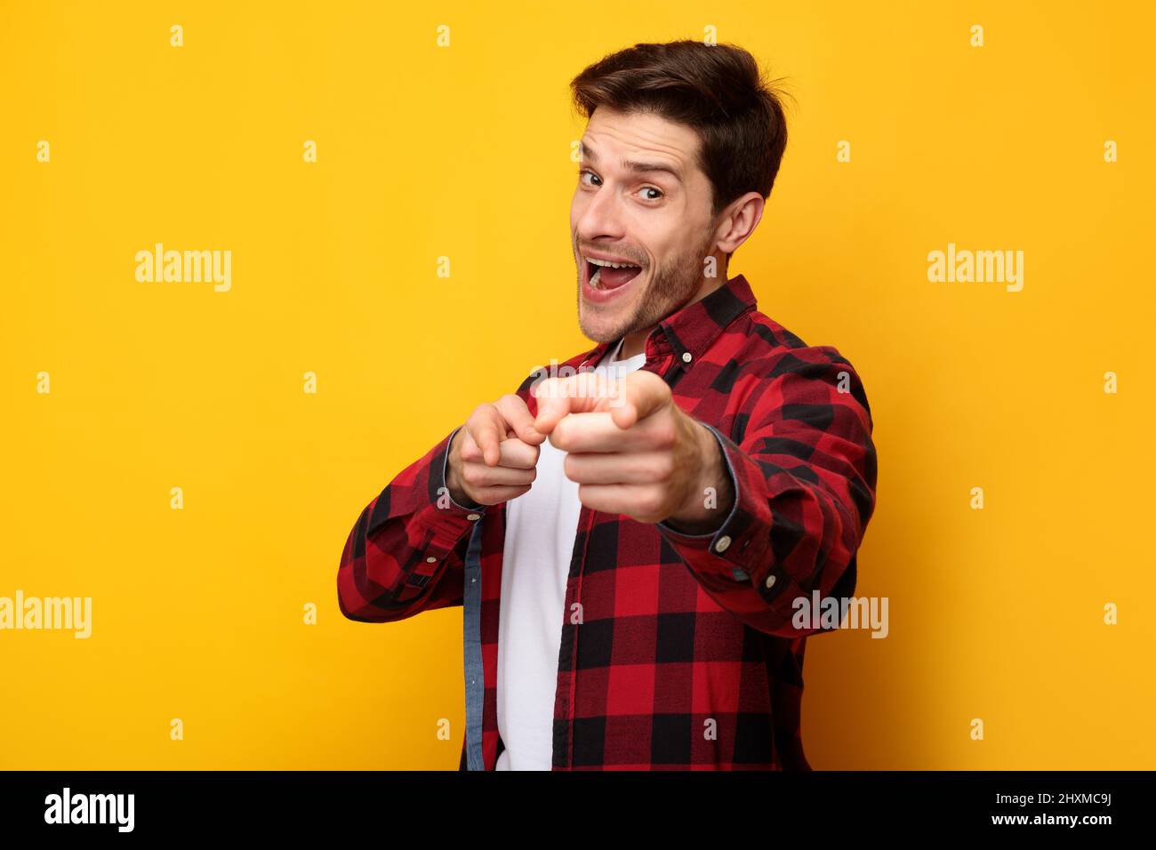 Happy young man pointing fingers at camera at studio Stock Photo - Alamy