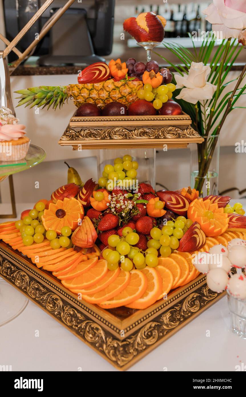 Different fresh fruits on wedding buffet table. Wedding reception catering table with different ...