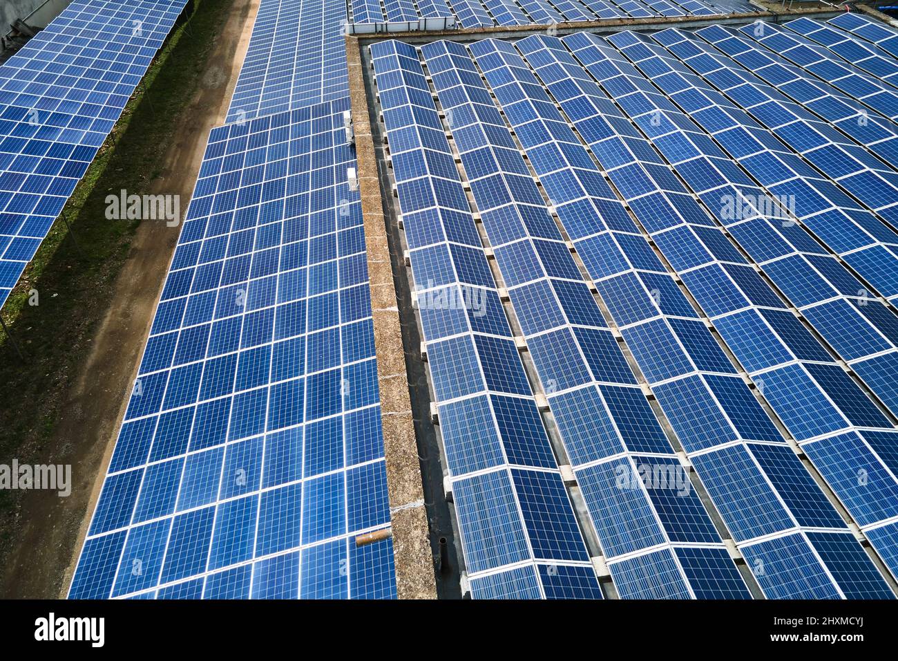 Aerial view of blue photovoltaic solar panels mounted on industrial ...