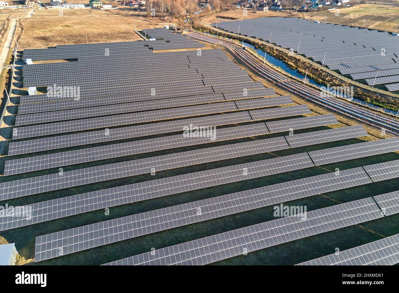 Aerial view of large sustainable electrical power plant with rows of solar photovoltaic panels ...