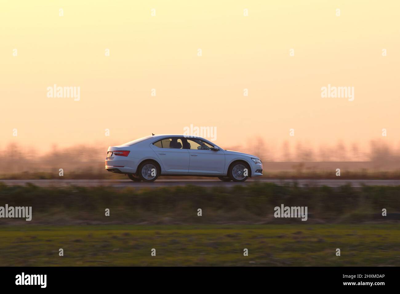 Car driving fast on intercity road at sunset. Highway traffic in ...