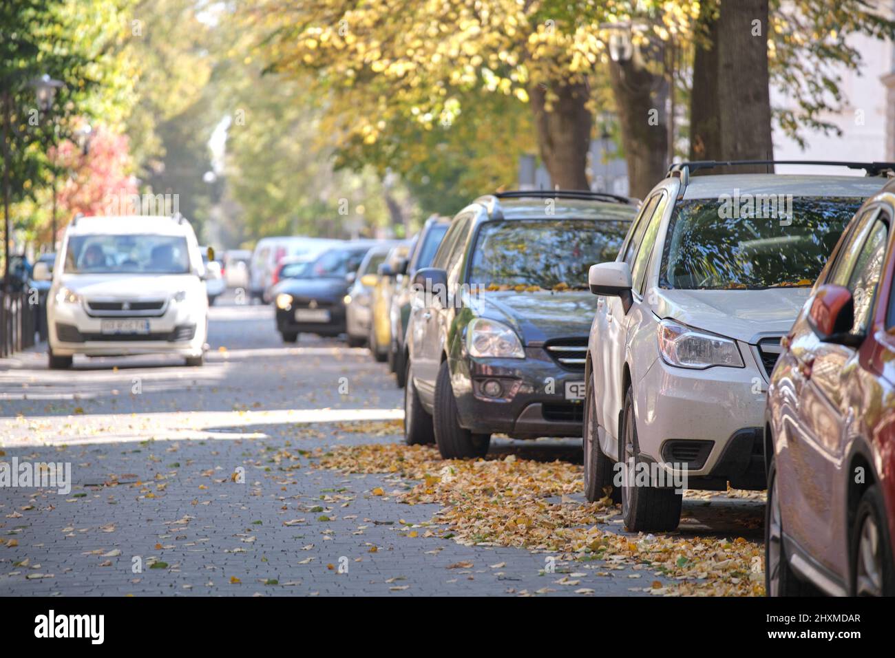 City traffic with many cars parked in line on street side Stock Photo ...