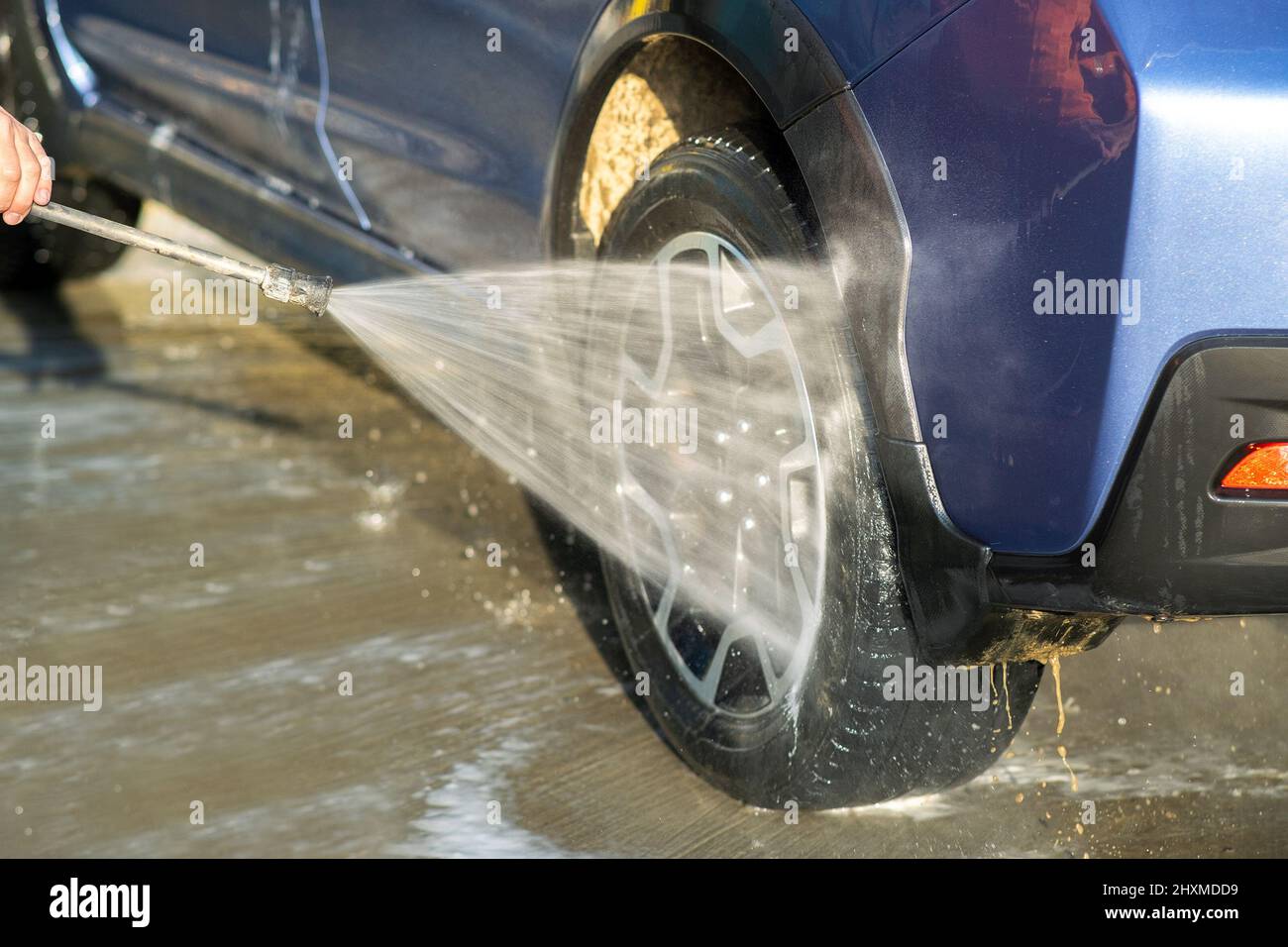Closeup of male driver washing his car with contactless high pressure ...