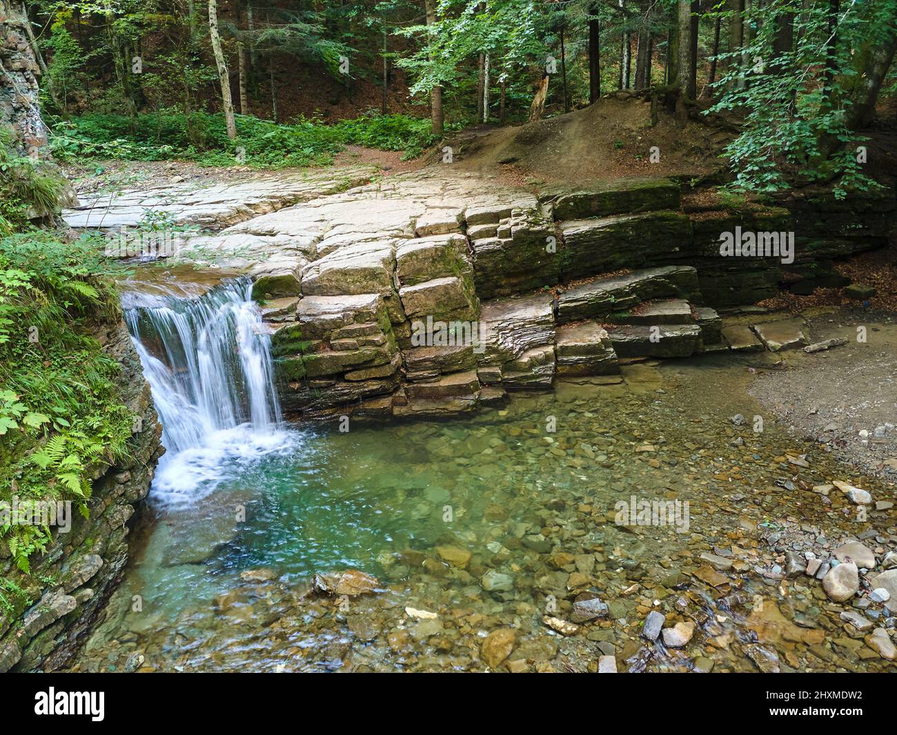 Waterfall on mountain river with white foamy water falling down from ...
