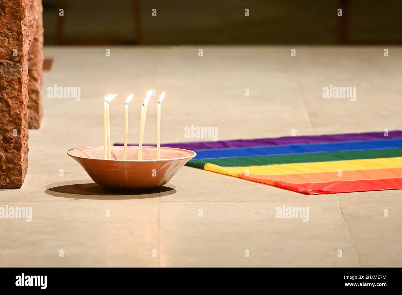 Munich, Germany. 13th Mar, 2022. Candles and a rainbow flag stand in ...