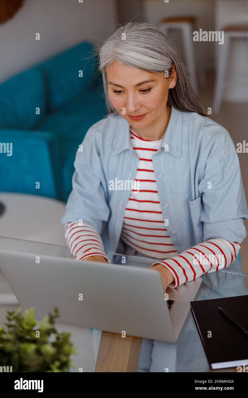 Woman typing on laptop keyboard at home Stock Photo - Alamy
