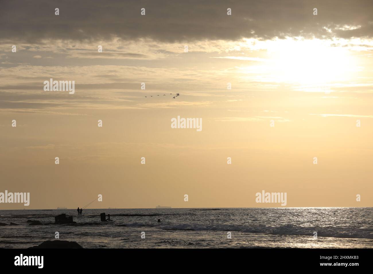 Sunset and sun lights comes between clouds to ocean Stock Photo - Alamy