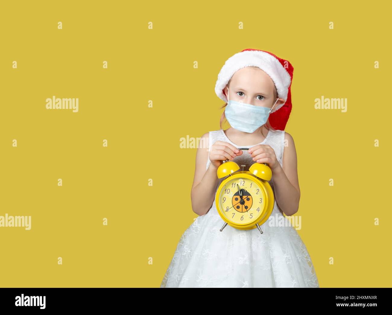 Six-year old caucasian girl with alarm clock and unhappy emotion and ...