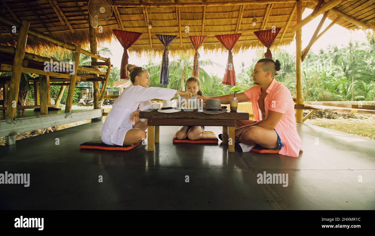 The happy family eat and drink tasty beverages spending time in local ...