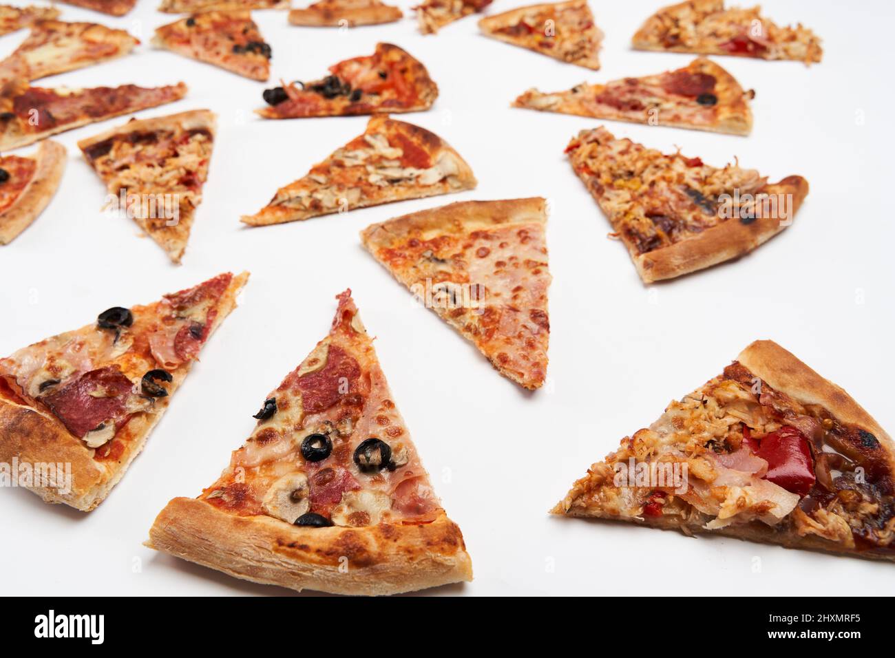 Closeup of freshly baked pizza slices isolated on white background ...
