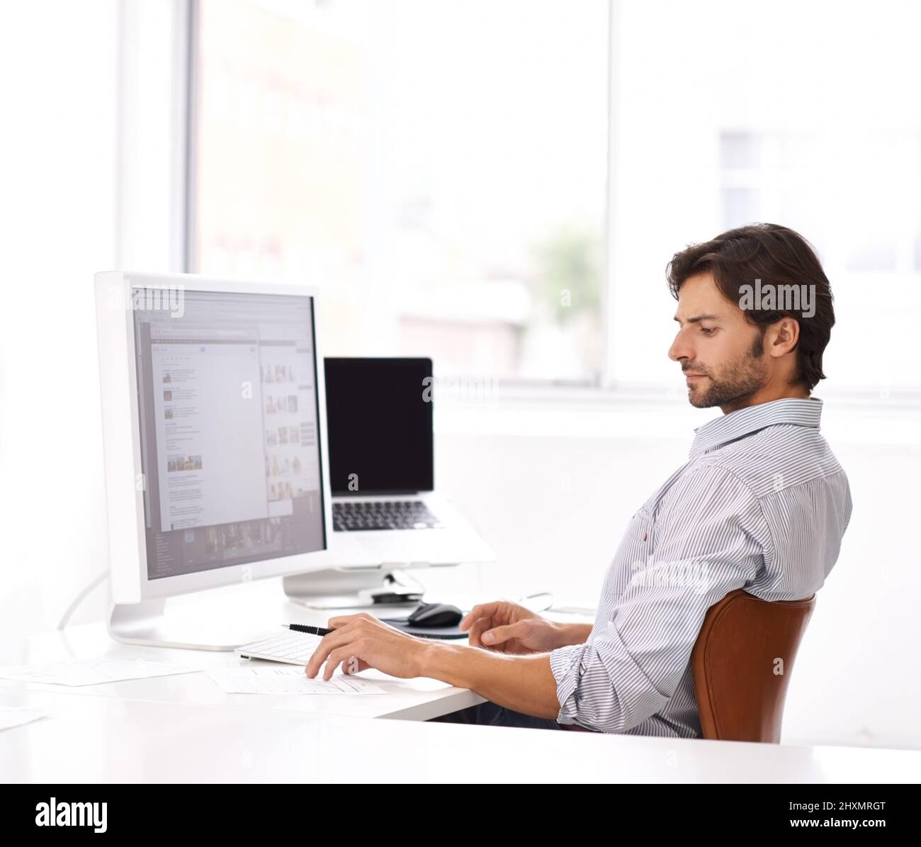 Never far from his workstation. A handsome young man at his desk in an ...