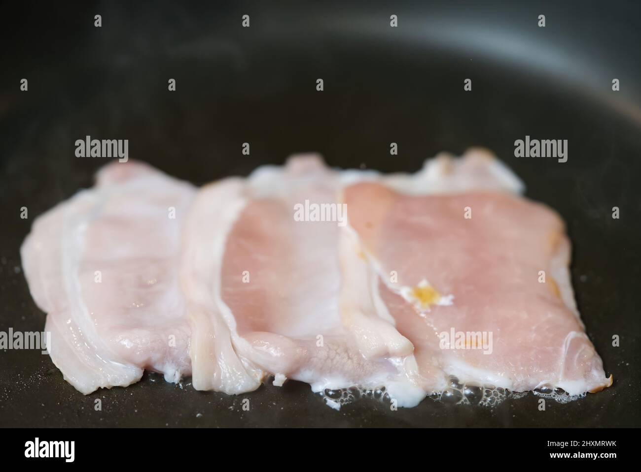 bacon in a pan. home food making process Stock Photo - Alamy