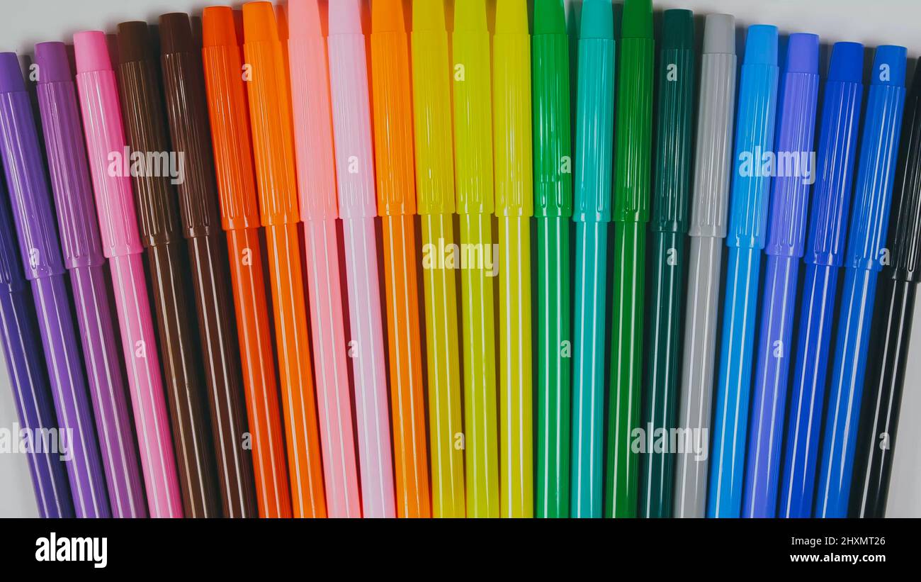 Many colored pencils are arranged around the edges of the image as a ...