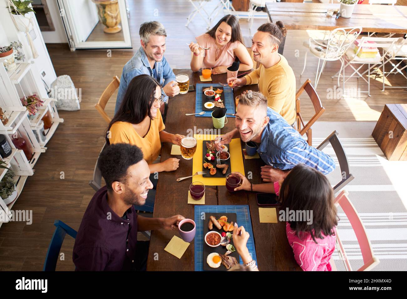 Cheerful multiethnic Friends in the terrace bar Pub. Drinking beer ...