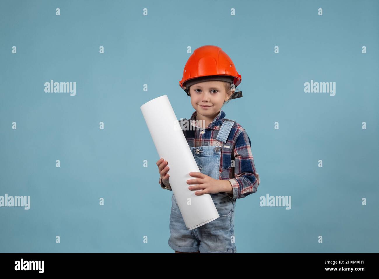 Portrait of cute little caucasian girl builder in hardhats holding ...