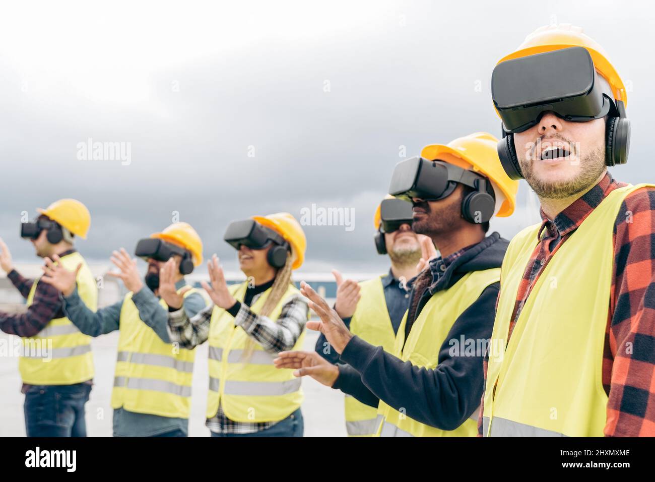 Multiracial team of industrial workers using virtual reality headsets ...