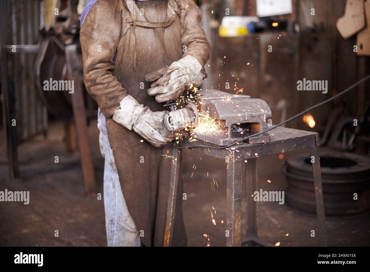 Making the magic happen. A man grinding metal in a workshop Stock Photo ...