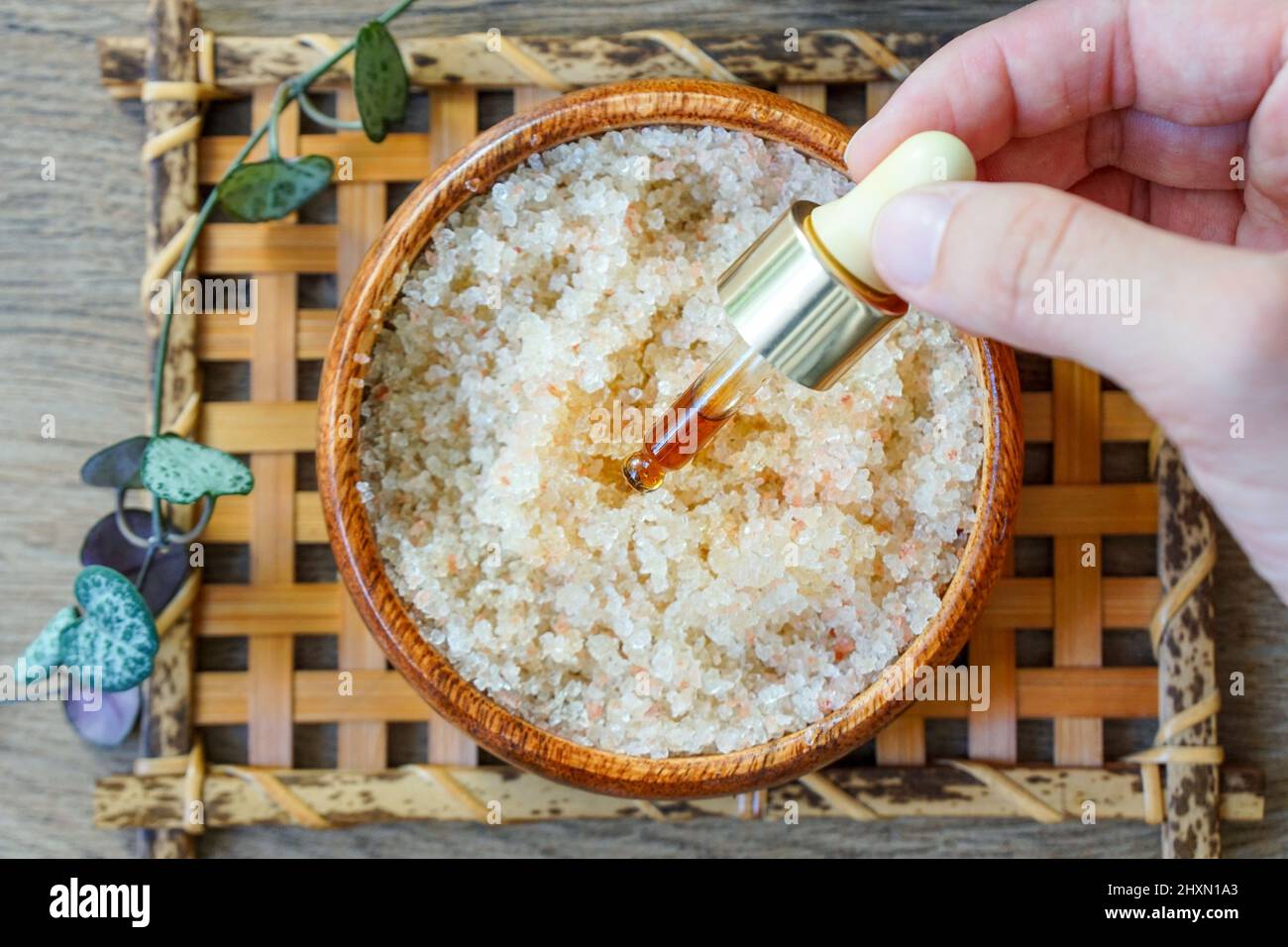 Hand adding essential oil to skin scrub Stock Photo - Alamy