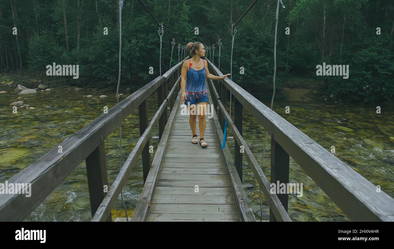 Woman Walking Along Suspension Bridge Alone in Picturesque Green Forest ...