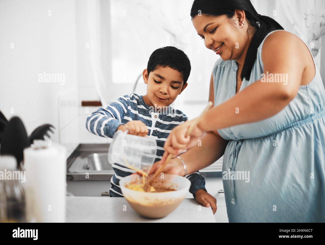 Kids can learn many skills by baking with parents. Shot of a mother and ...