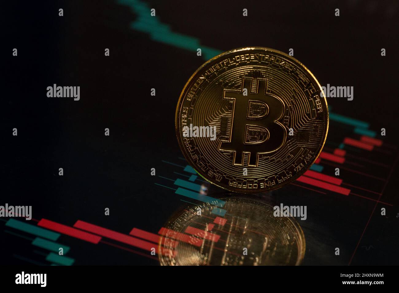 Golden Bitcoin token with candlestick chart background. Digital ...