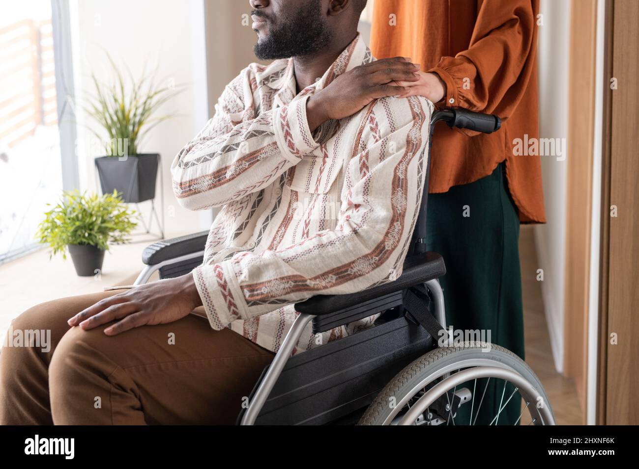 Side view of young African American man with disability keeping his ...