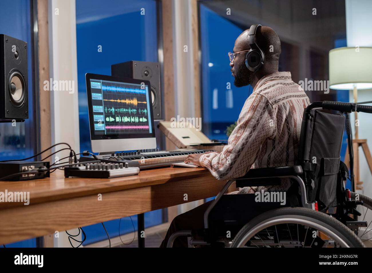 Young serious African American musician with disability looking at ...