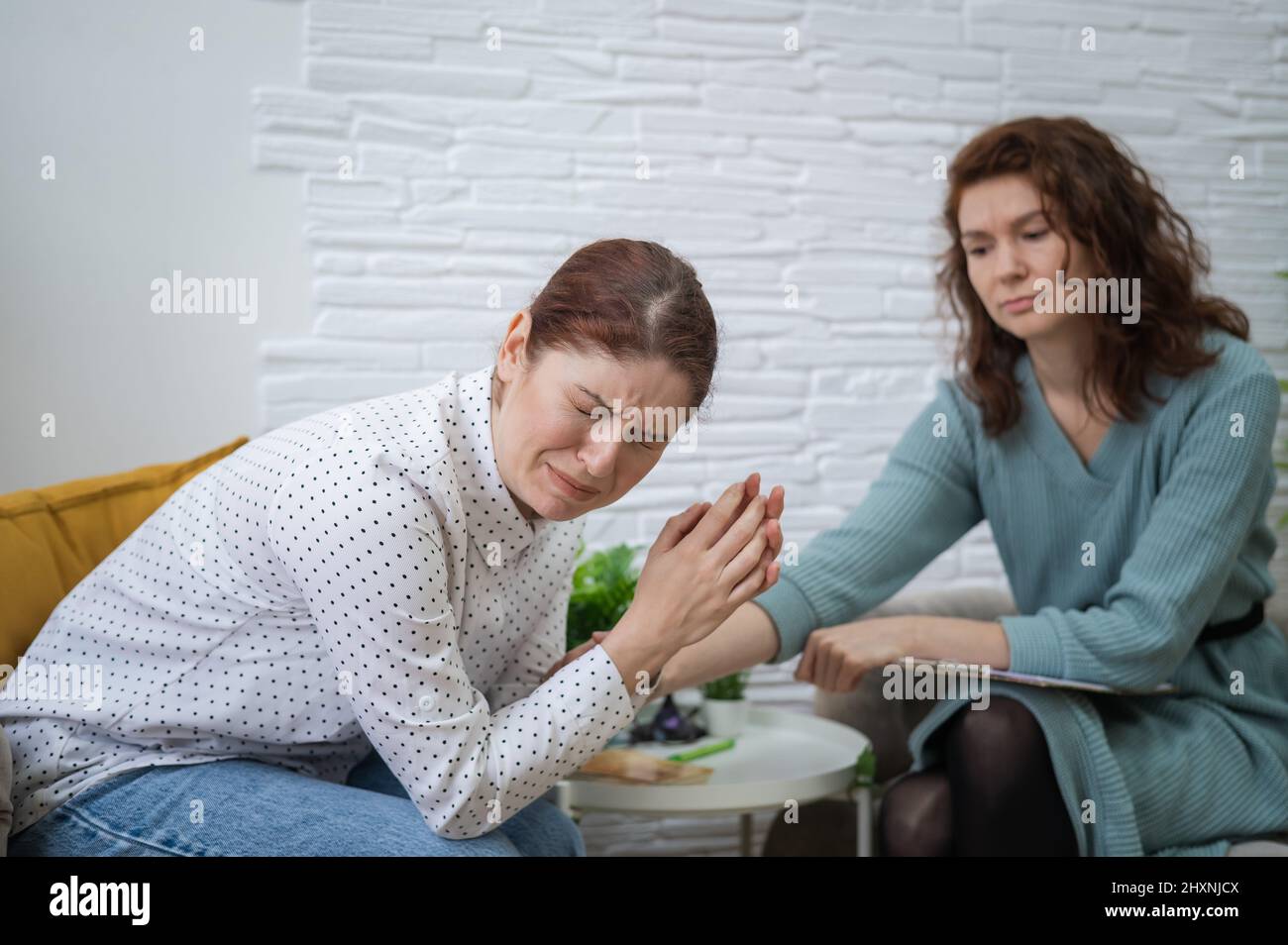 Caucasian woman crying at psychotherapy session. The female doctor ...