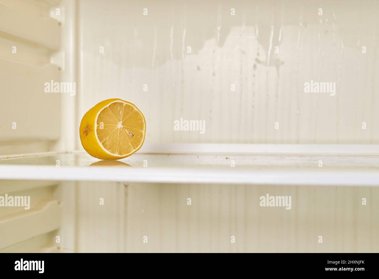 Half a lemon is on the shelf of an empty refrigerator Stock Photo - Alamy