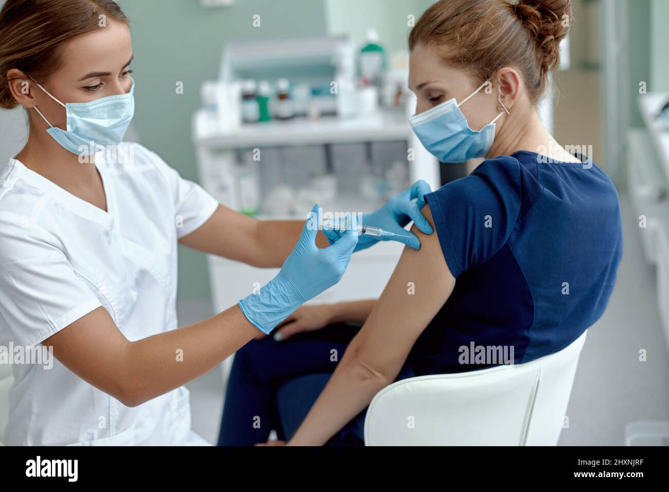 woman doctor holding syringe making covid 19 vaccination injection dose ...