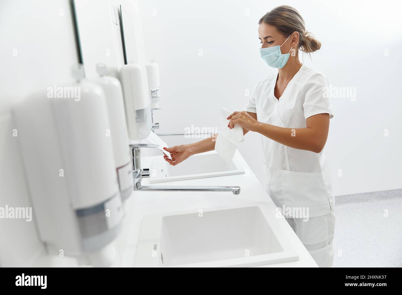 Hygiene, health care. Close up of female doctor or nurse drying hands ...