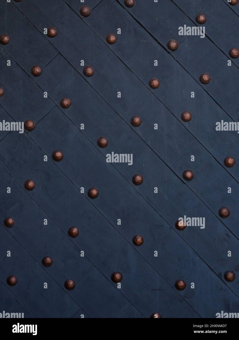 A strong black wooden door with heavy brown rivets Stock Photo - Alamy